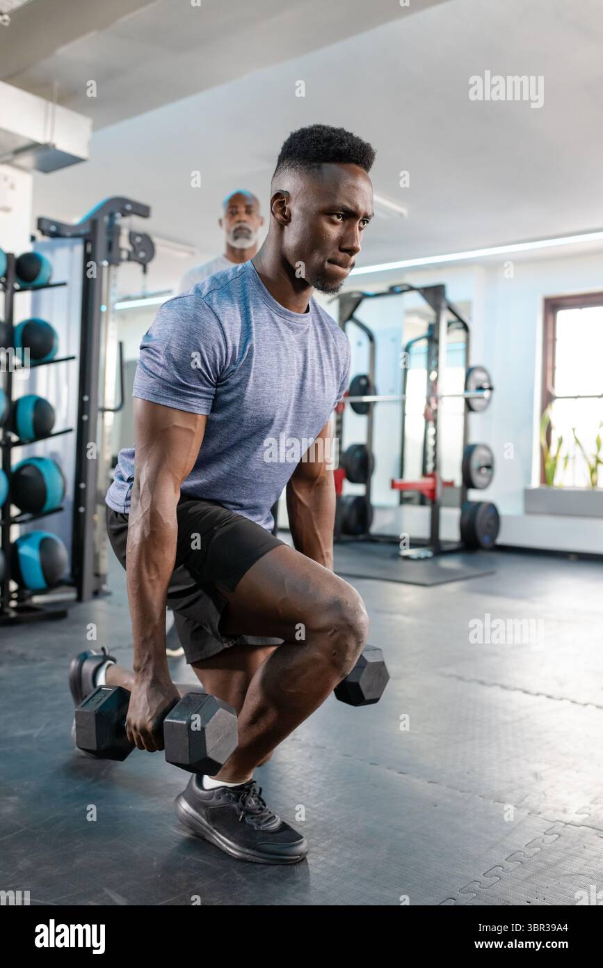African American trainer guiding client performing lunges with hex ...