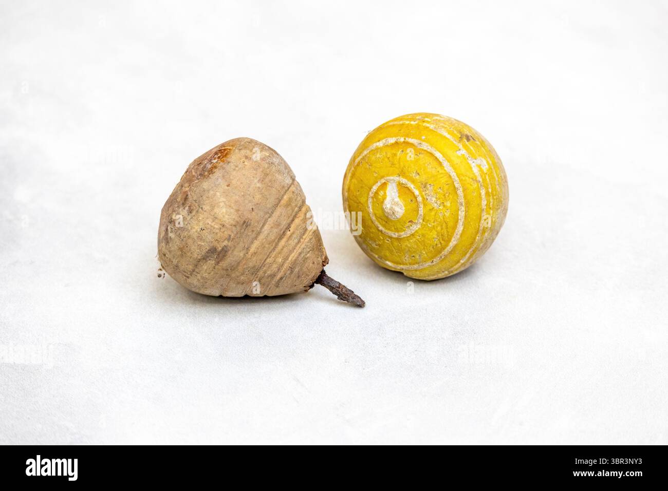 Two traditional spinning tops, wooden and plastic, isolated on white ...