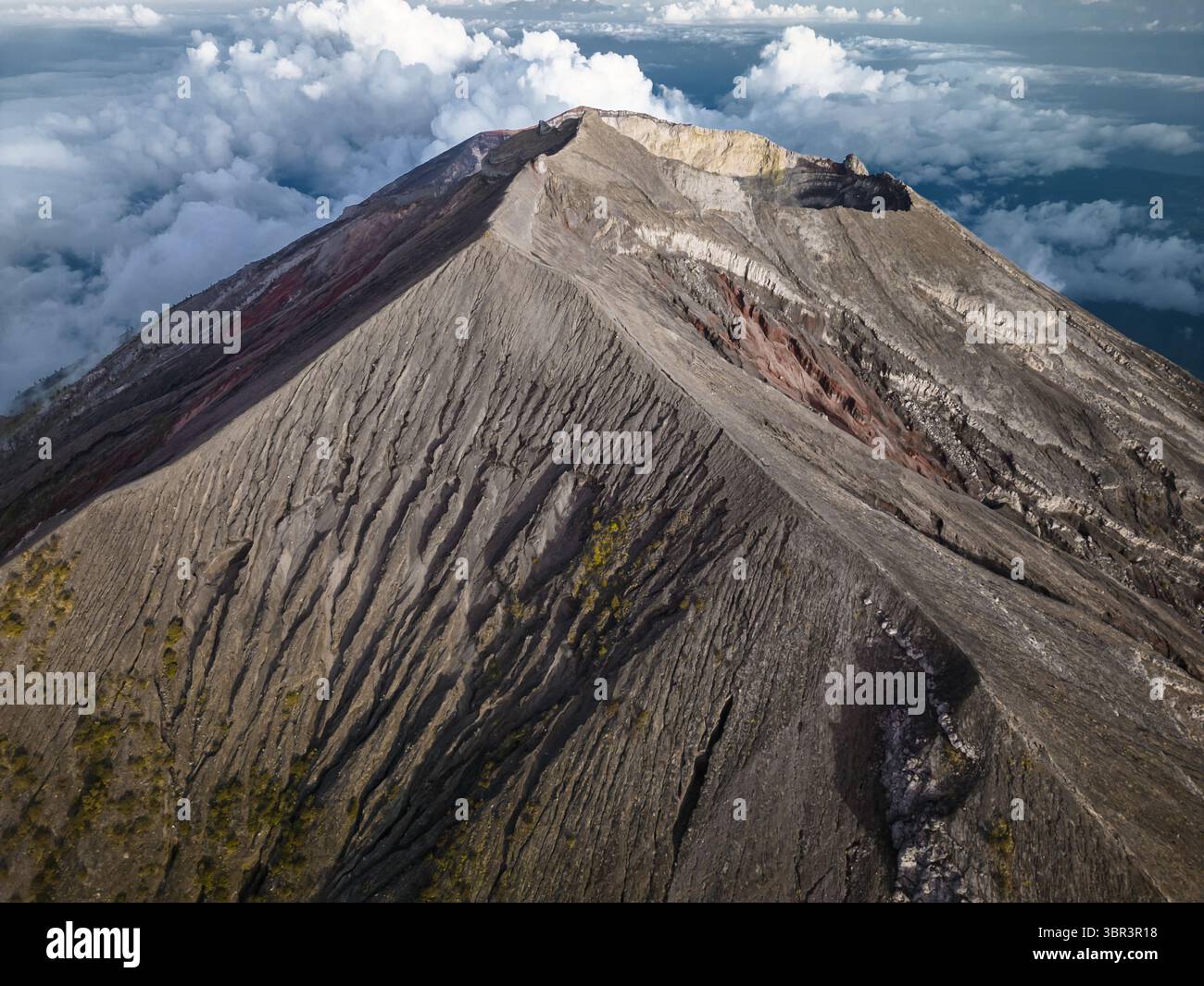 Aerial view of the imposing Agung volcano, its rugged slopes etched ...