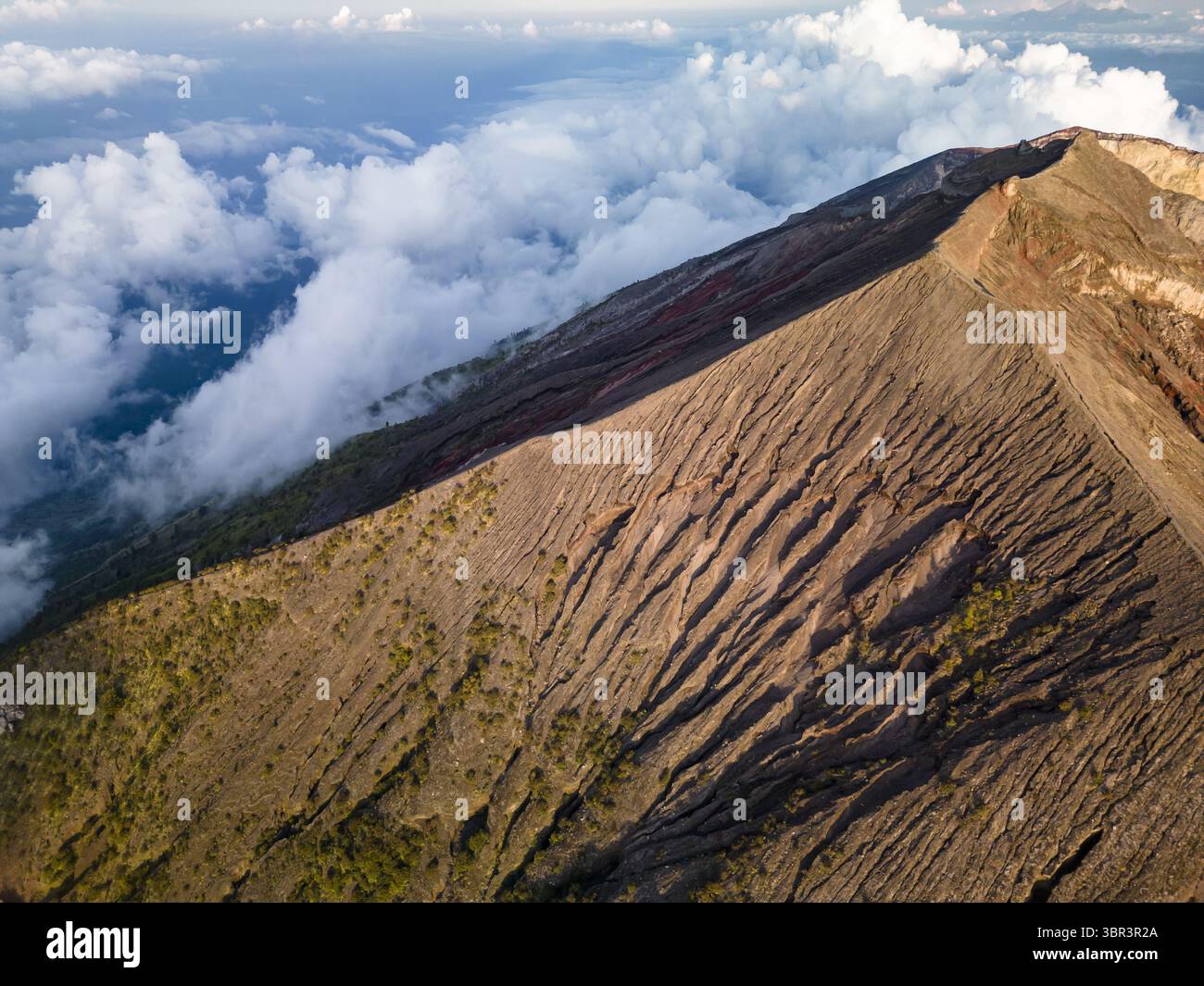 Aerial view of the majestic Agung volcano peak piercing through a sea ...