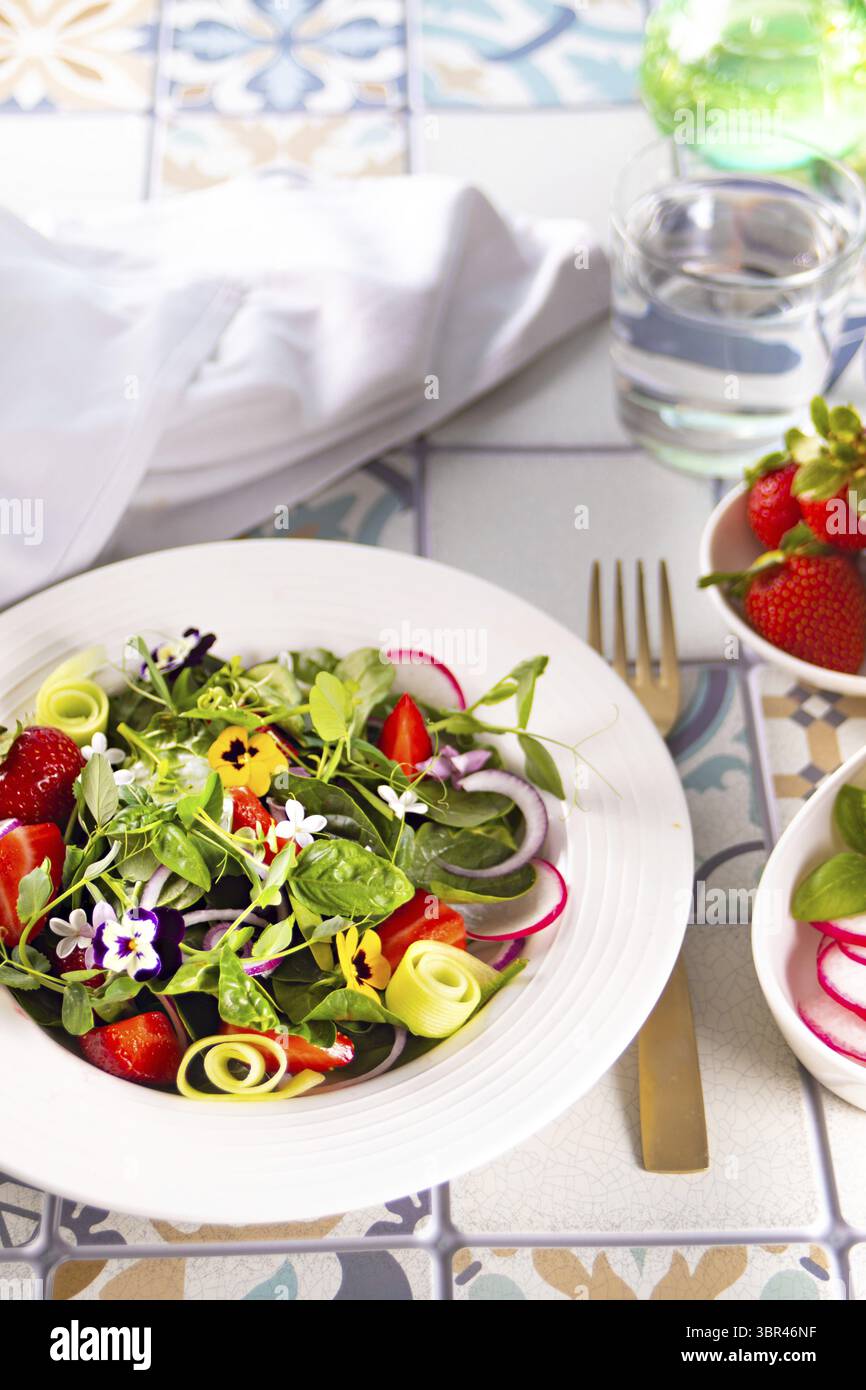 Spring healthy fresh salad with green, edible flowers pansies viola and ...
