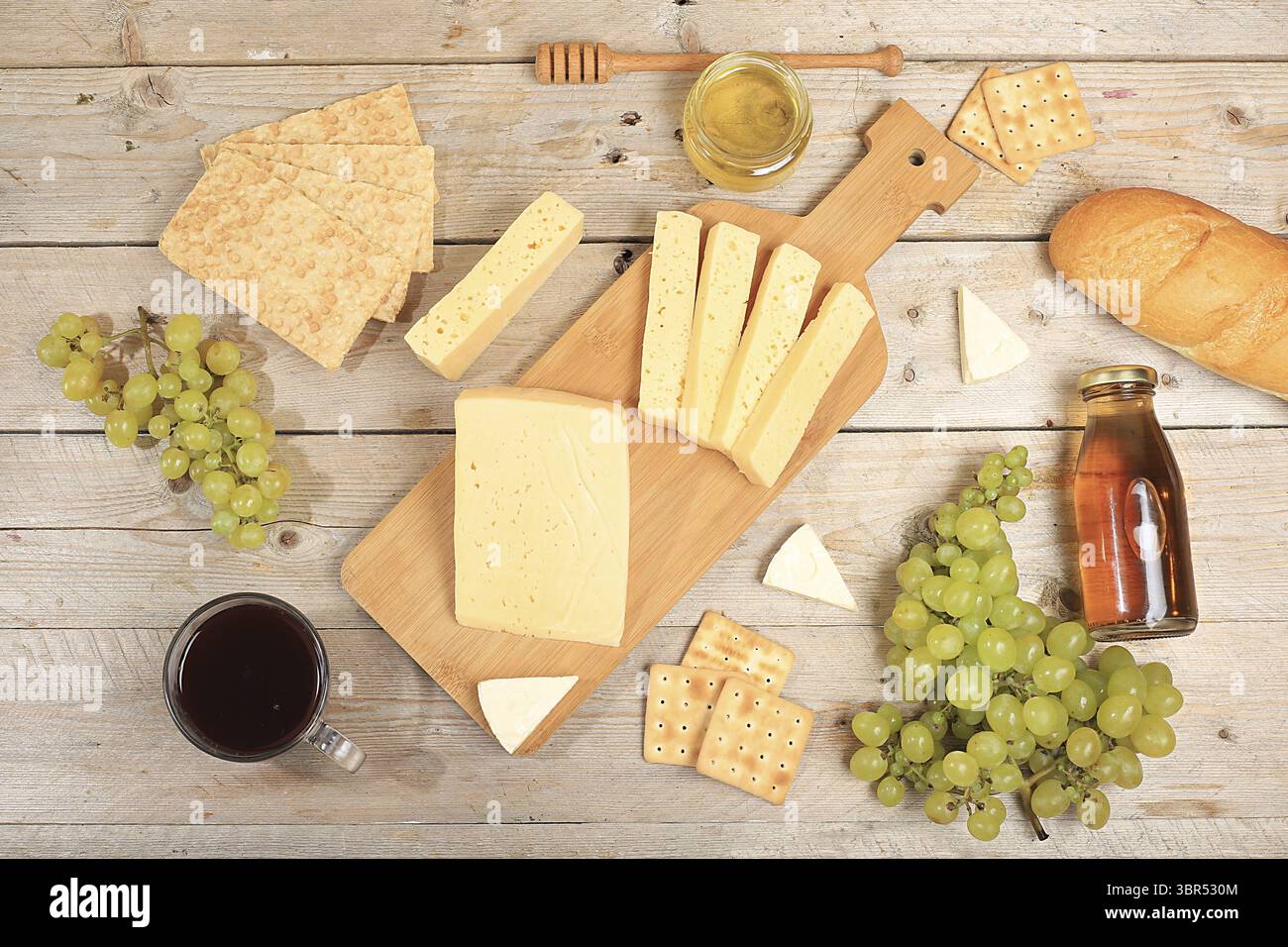 Assortment of different varieties of cheese, red wine, grapes and ...