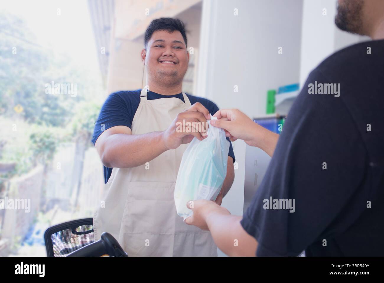 Young man standing near cashier hi-res stock photography and images - Alamy