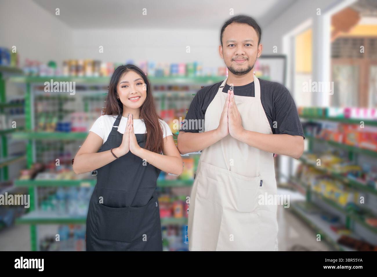 friendly Asian Cashier couple welcoming customers with open arms ...