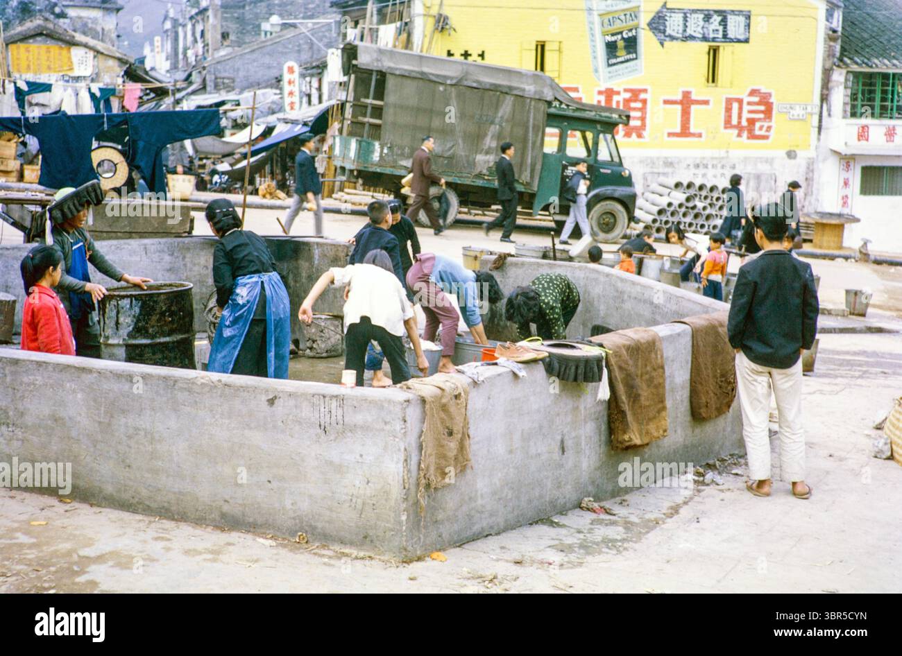 Women washing clothes in street at public laundry place, Shung Tak ...