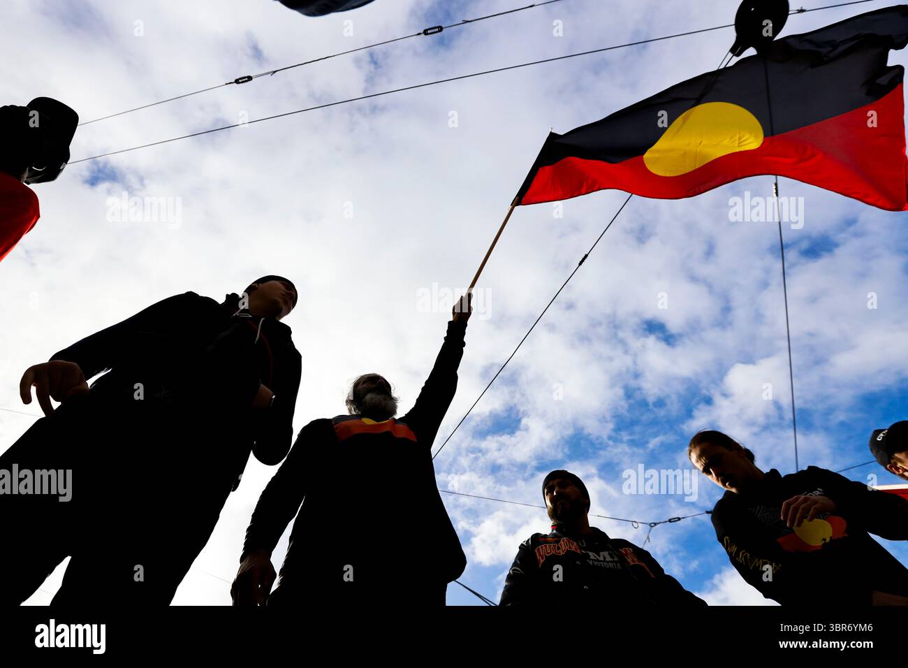 A participant waves an Aboriginal flag during the VIC NAIDOC March. The ...