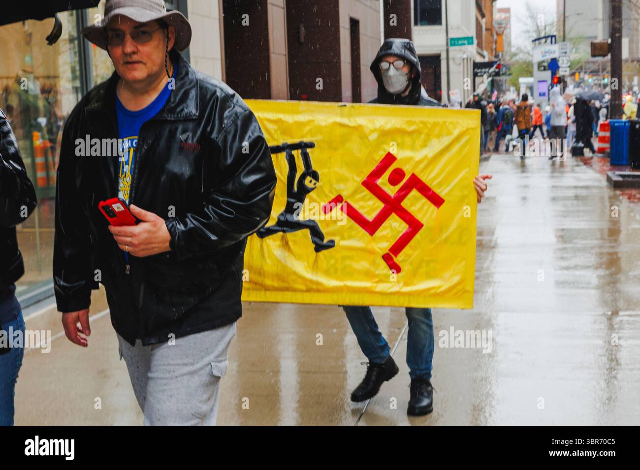 Masked man carries anti-Nazi sign at protest rally in rain Stock Photo ...