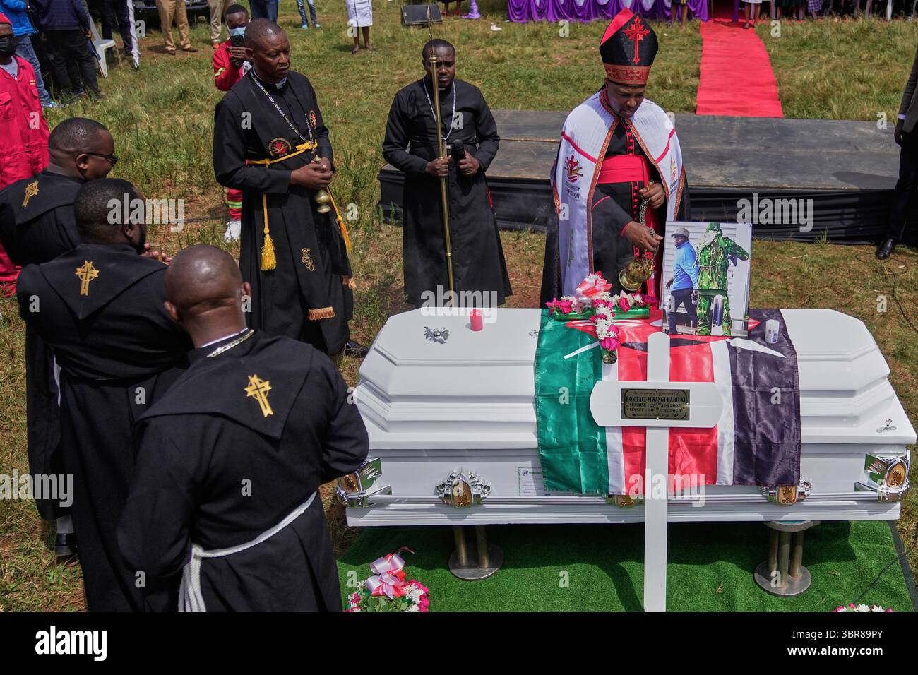 A priest blesses the casket of vendor Boniface Kariuki, who was shot at ...