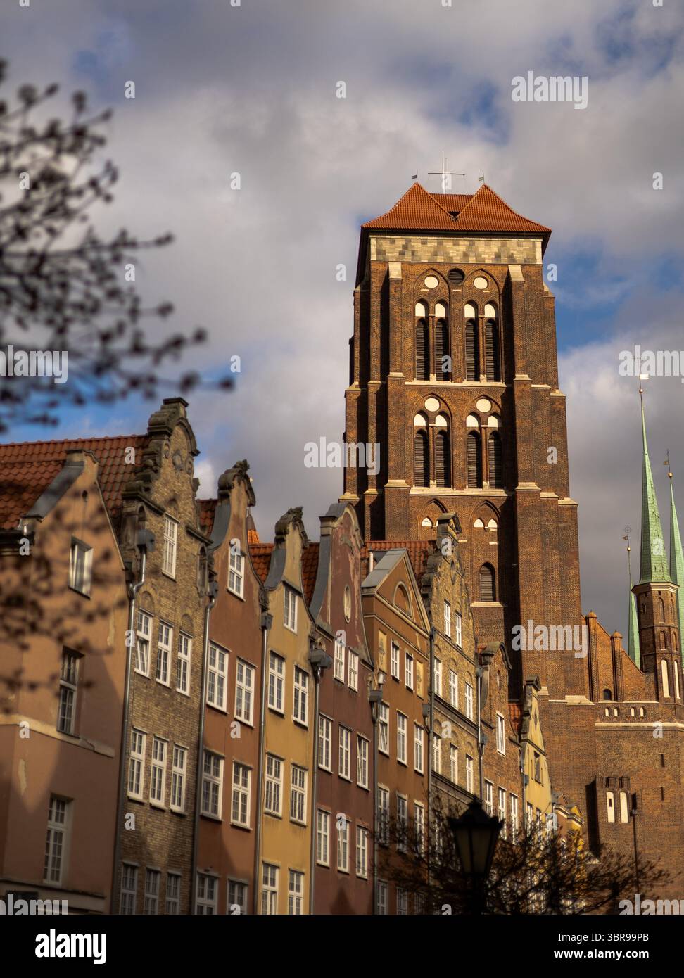 Historic colorful buildings and a towering brick church under a partly ...