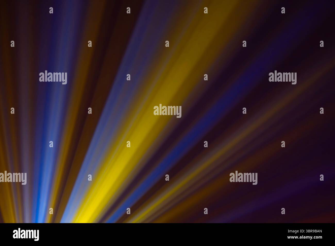radial light beams in shades of yellow, blue, and purple emanating from ...