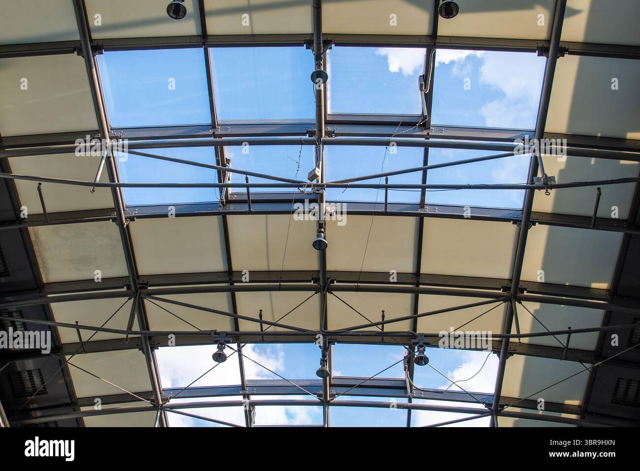 Modern glass and steel ceiling structure with transparent panels and ...