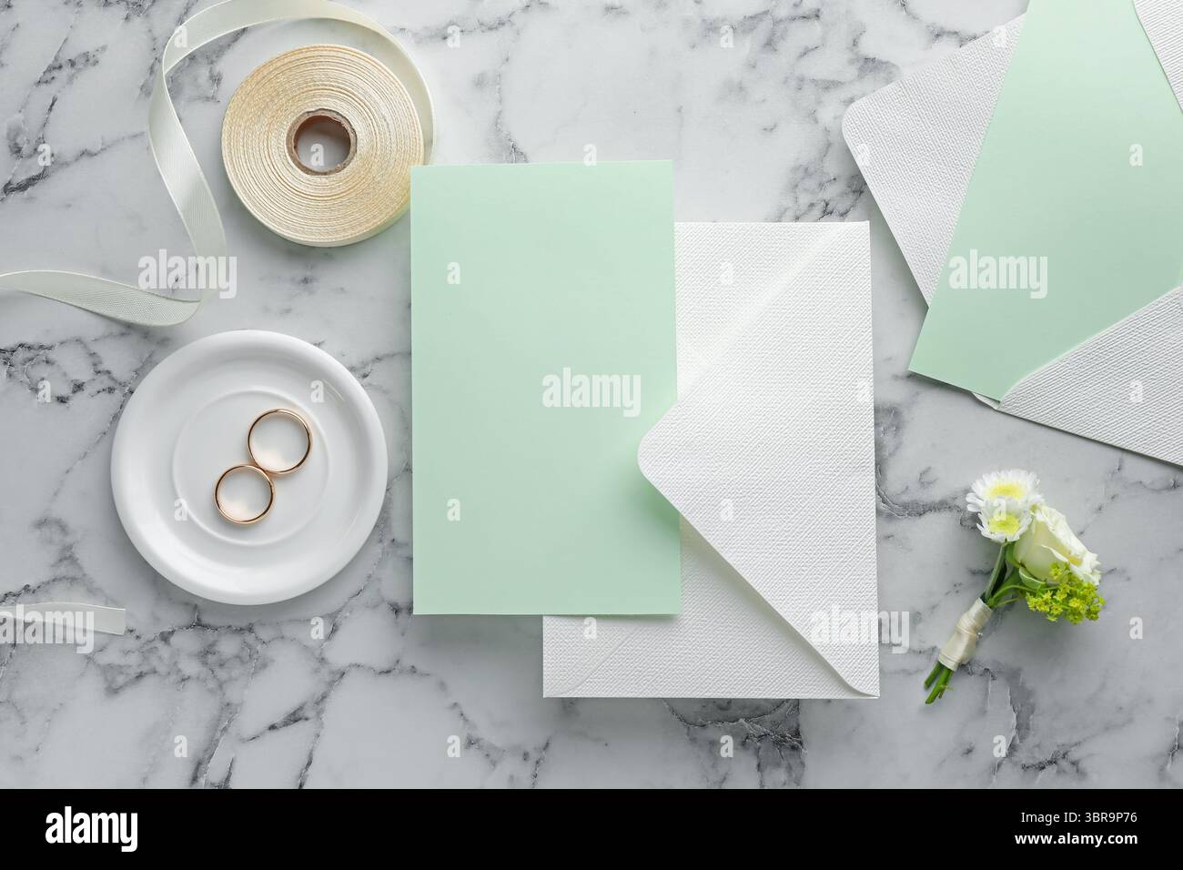 Wedding invitation card, golden rings, ribbon and envelope on white ...