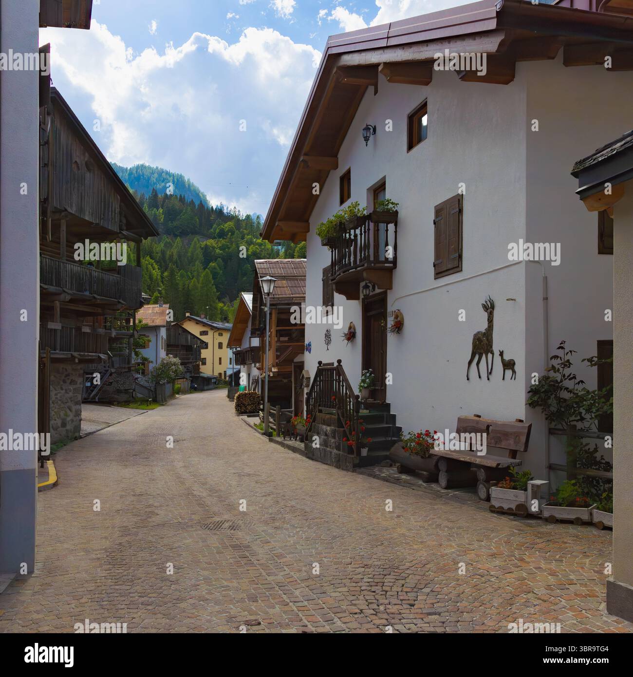 A picturesque cobblestone street in Sottoguda, featuring traditional ...
