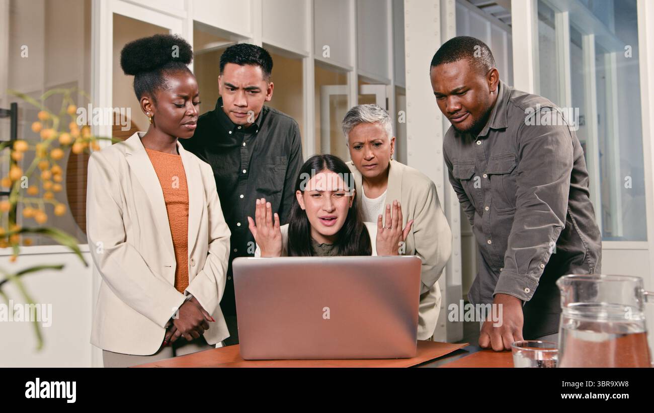 Team of Colleagues Expressing Concern Around a Laptop in a Modern ...