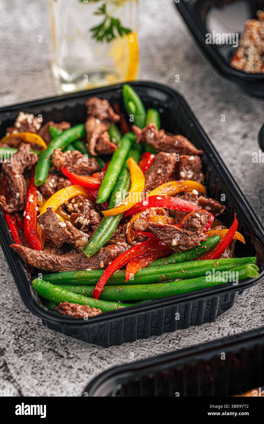 Beef stir-fry with green beans and peppers in container Stock Photo - Alamy