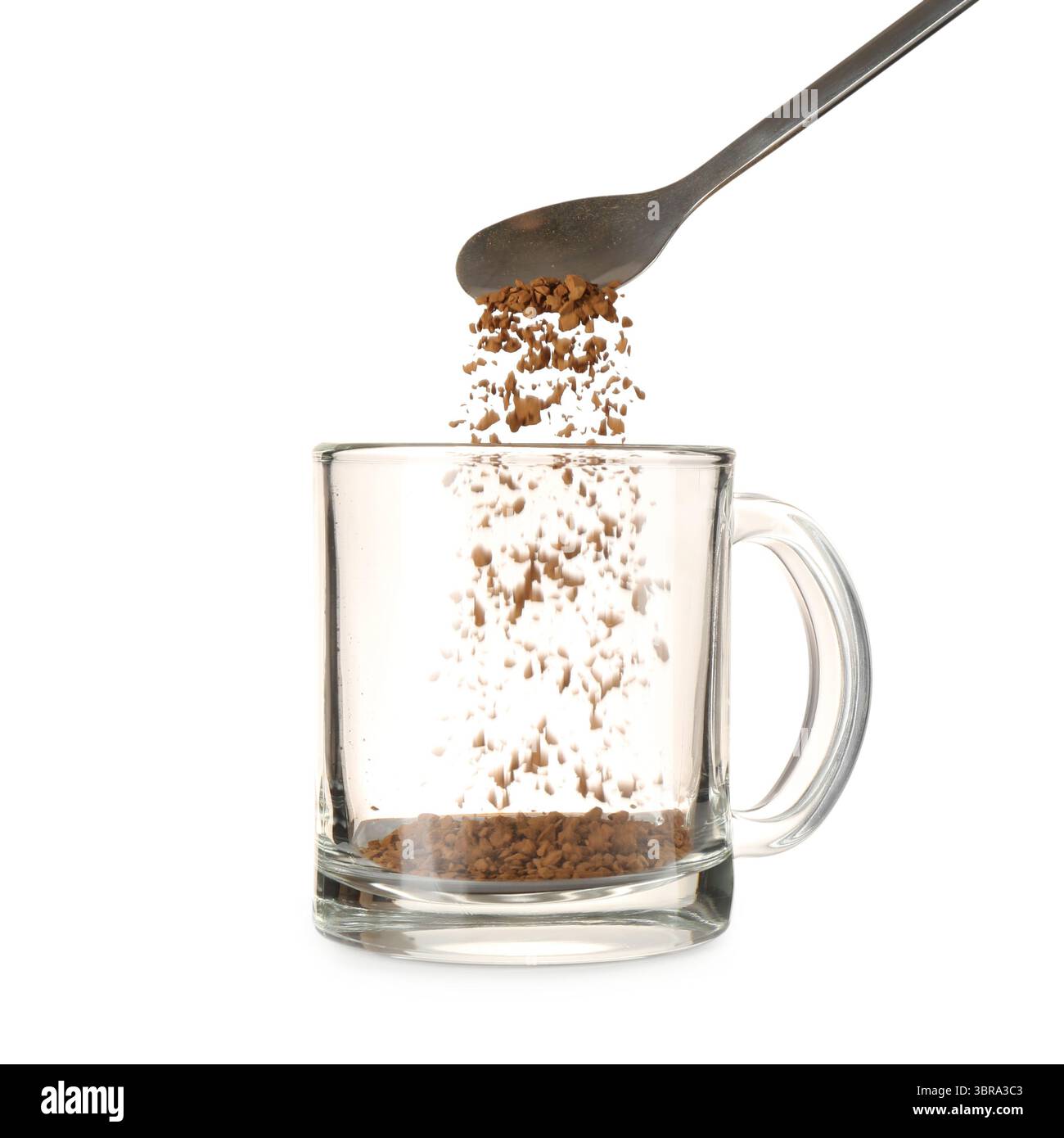 Adding granulated instant coffee from spoon into glass cup isolated on ...