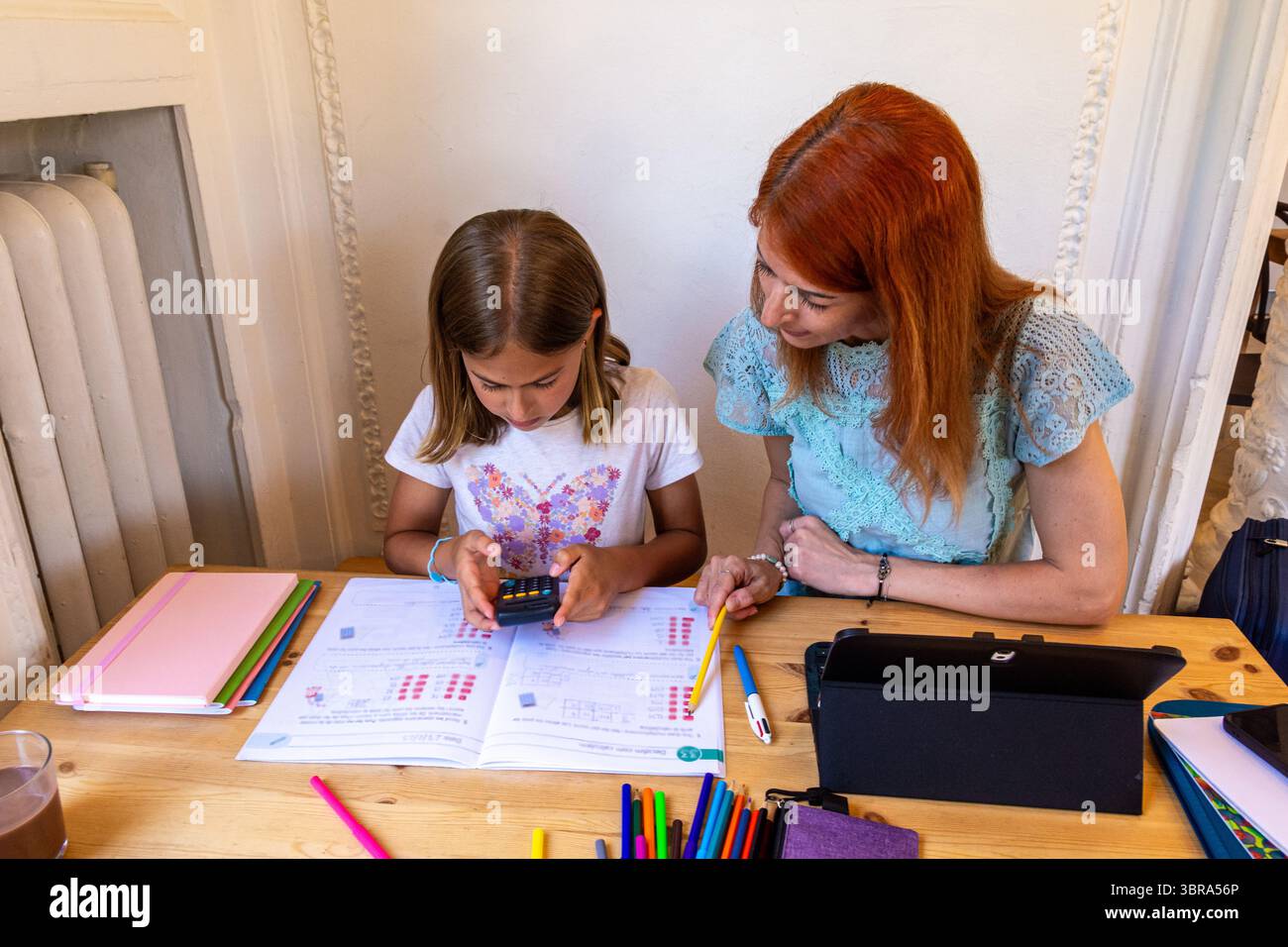 Mother helping daughter with math homework at home Stock Photo - Alamy