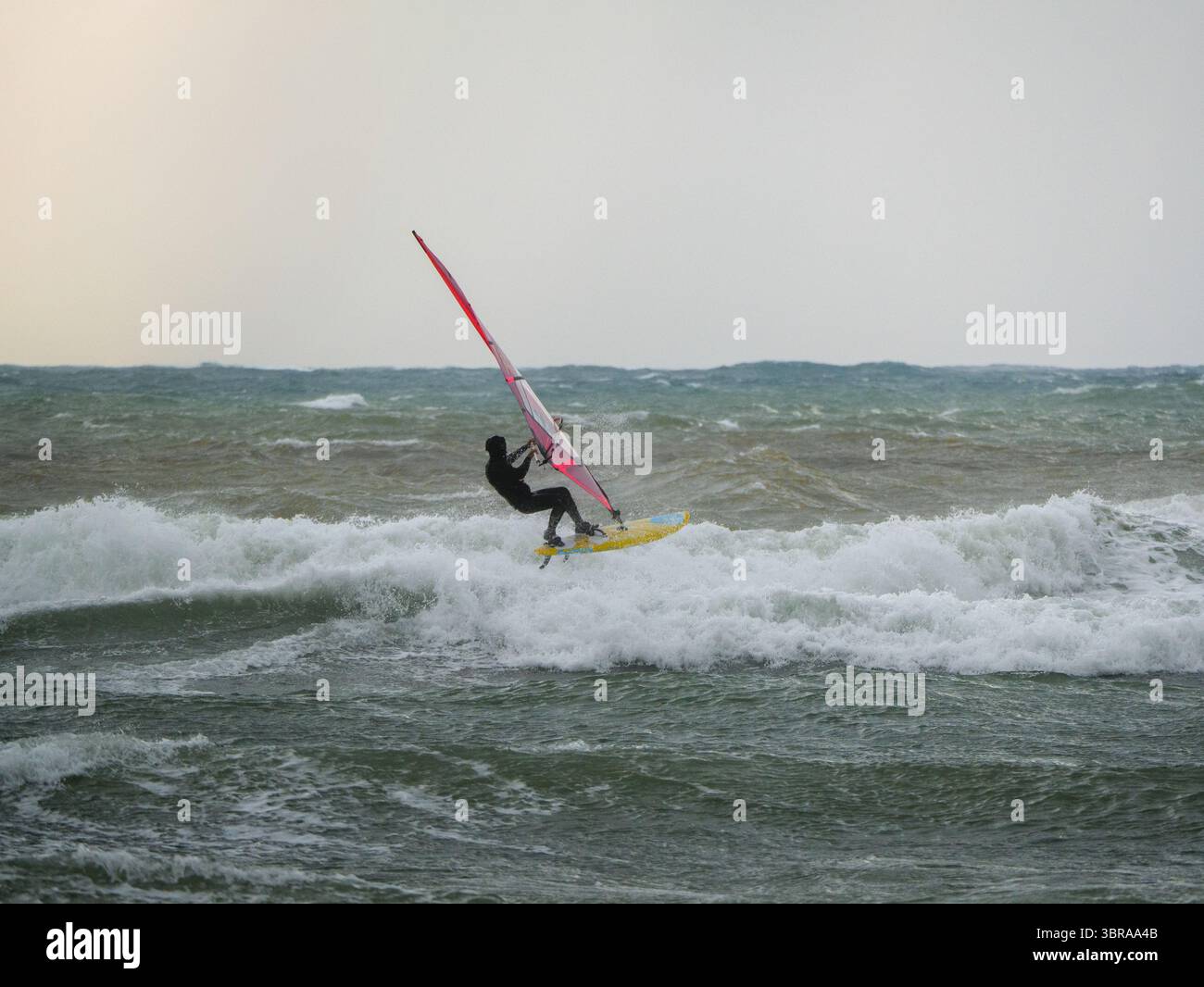 Water Sport Activity - Windsurfer Riding a Wave in Rough Sea on a Windy ...