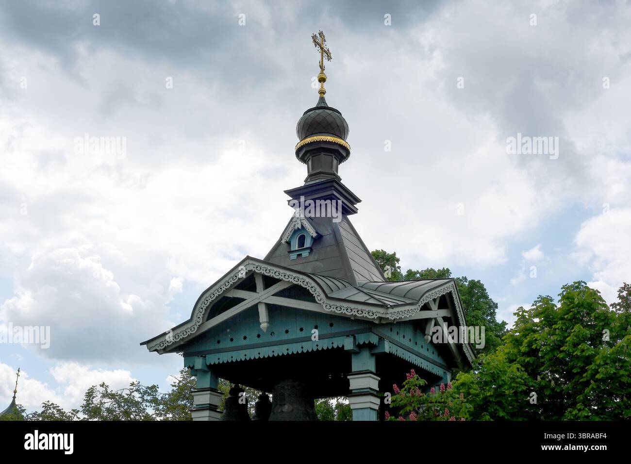 A striking bell tower stands among trees, showcasing intricate designs ...