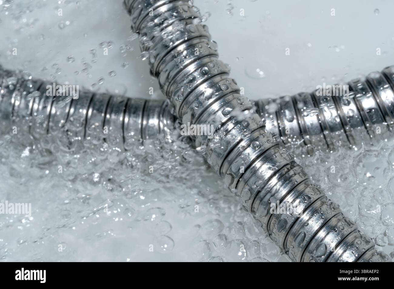 Sparkling water cascades around twisted steel tubing in motion Stock ...