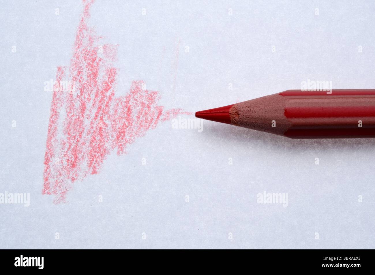 A bright red crayon softly marks white paper, sparks of creativity ...