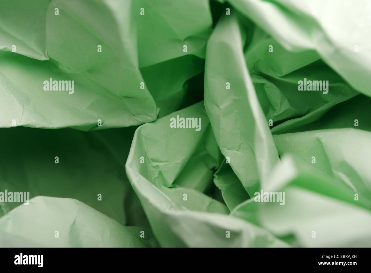 Layers of crumpled green paper intertwine, creating a mesmerizing ...
