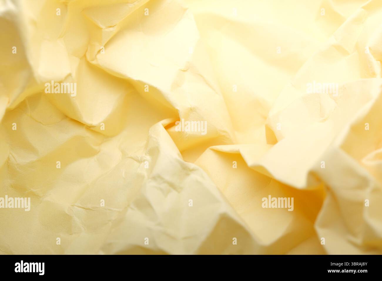 Textured surface of crumpled paper displays subtle shades and shadows ...