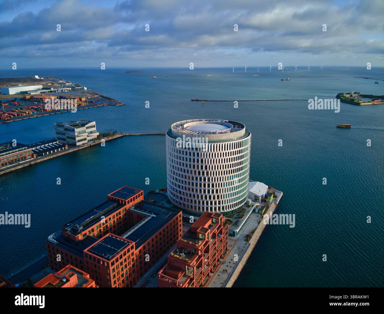 Aerial view of a modern cylindrical building with white facade and red ...