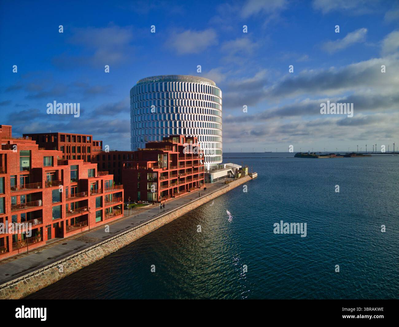 Aerial view of modern red brick buildings and a futuristic cylindrical ...
