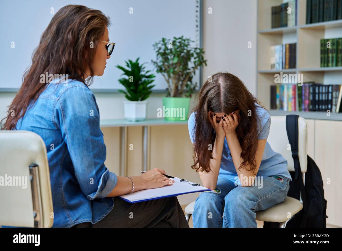 Sad teenage girl in mental therapy session, talking with school ...