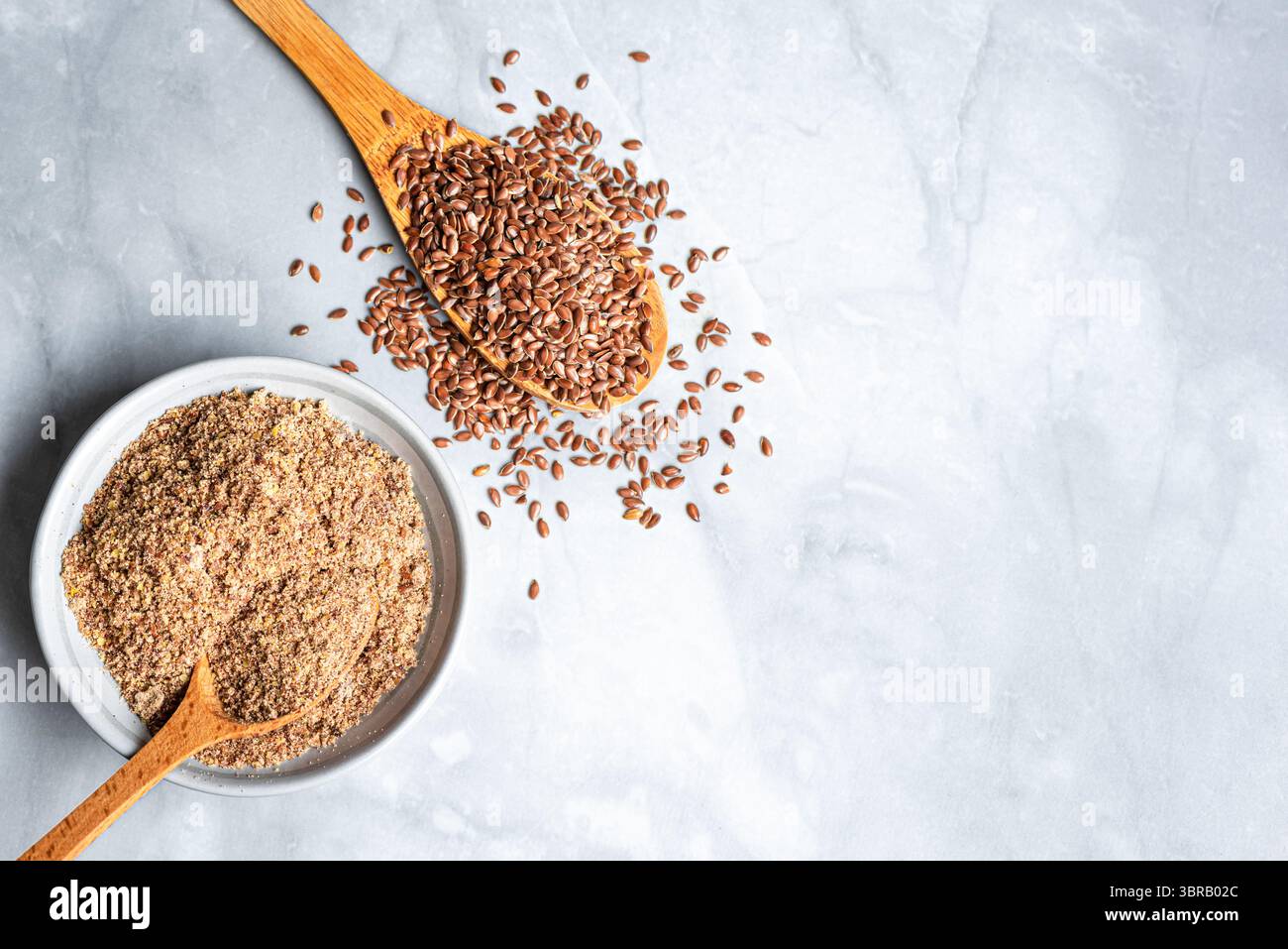 Flaxseeds whole and ground of flax seeds on marble background, top view ...
