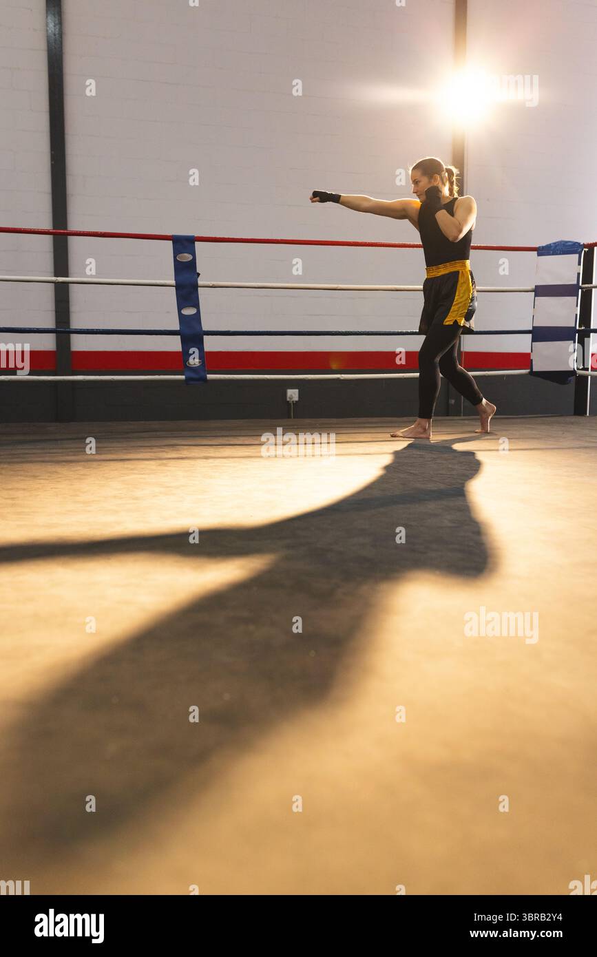 Female boxer wearing black sleeveless top and hand wraps jabbing in ...