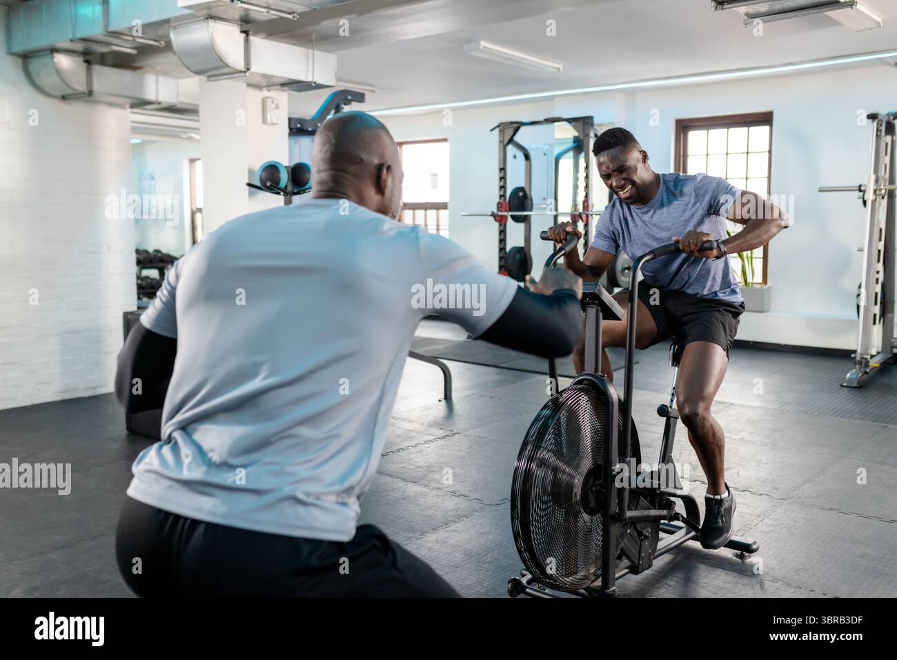 African American trainer and client performing workout in gym on air ...