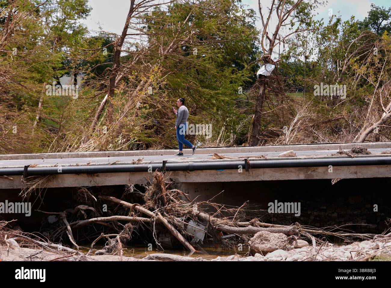Felicia Rodriguez walks on a pedestrian bridge over the Guadalupe River ...