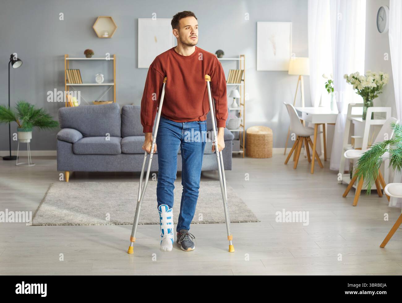 Broken leg or foot injury man walking on crutches with bandaged leg at ...