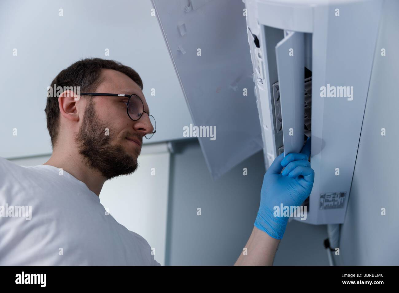 A Focused Individual Performing Maintenance on an Air Conditioning Unit ...