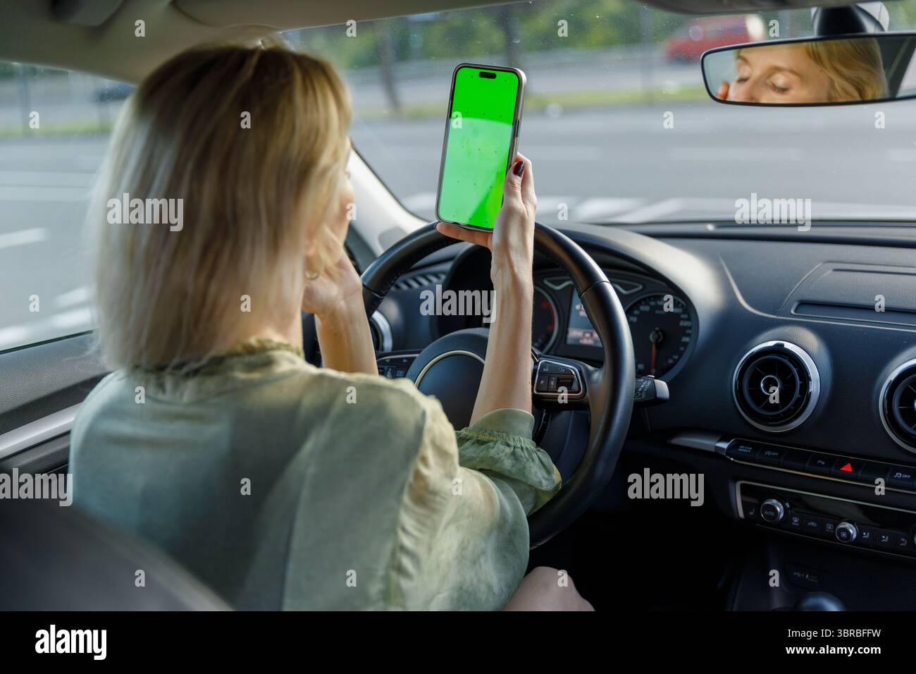 A woman in a vehicle gazing at her phone s green screen while possibly ...
