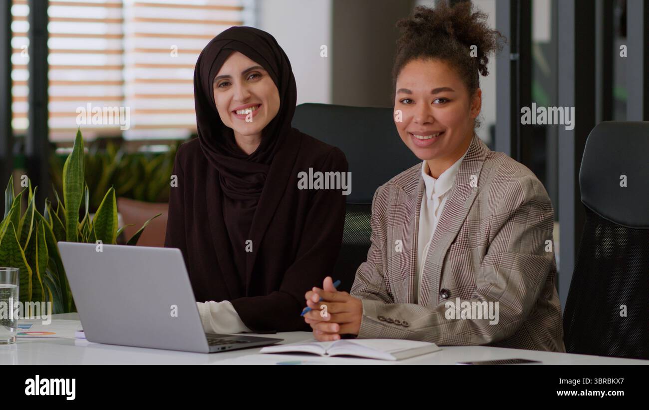 Two multiracial businesswomen female girls ethnic happy colleagues ...