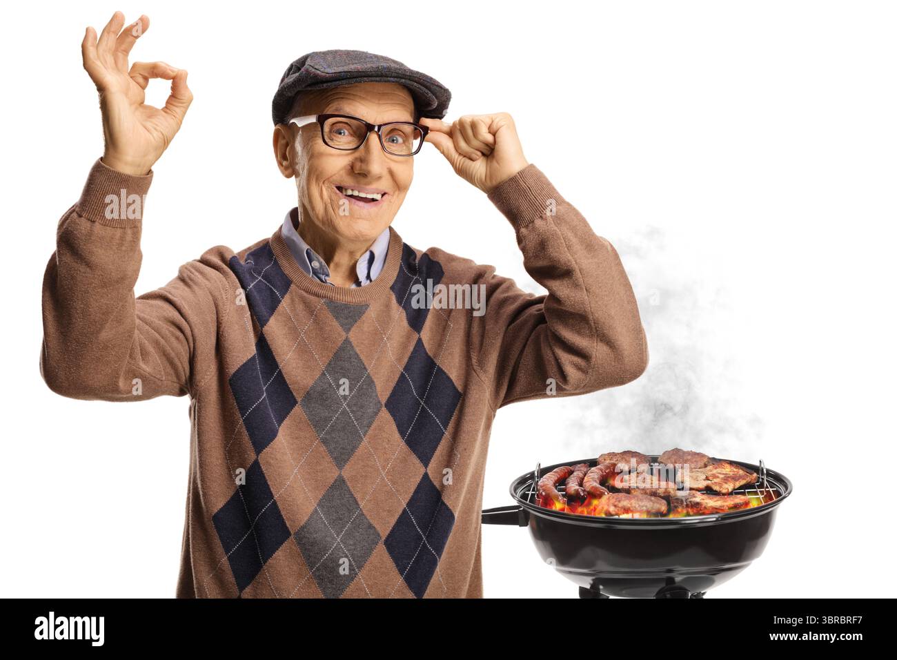 Smiling elderly man with a barbecue gesturing ok sign isolated on white ...