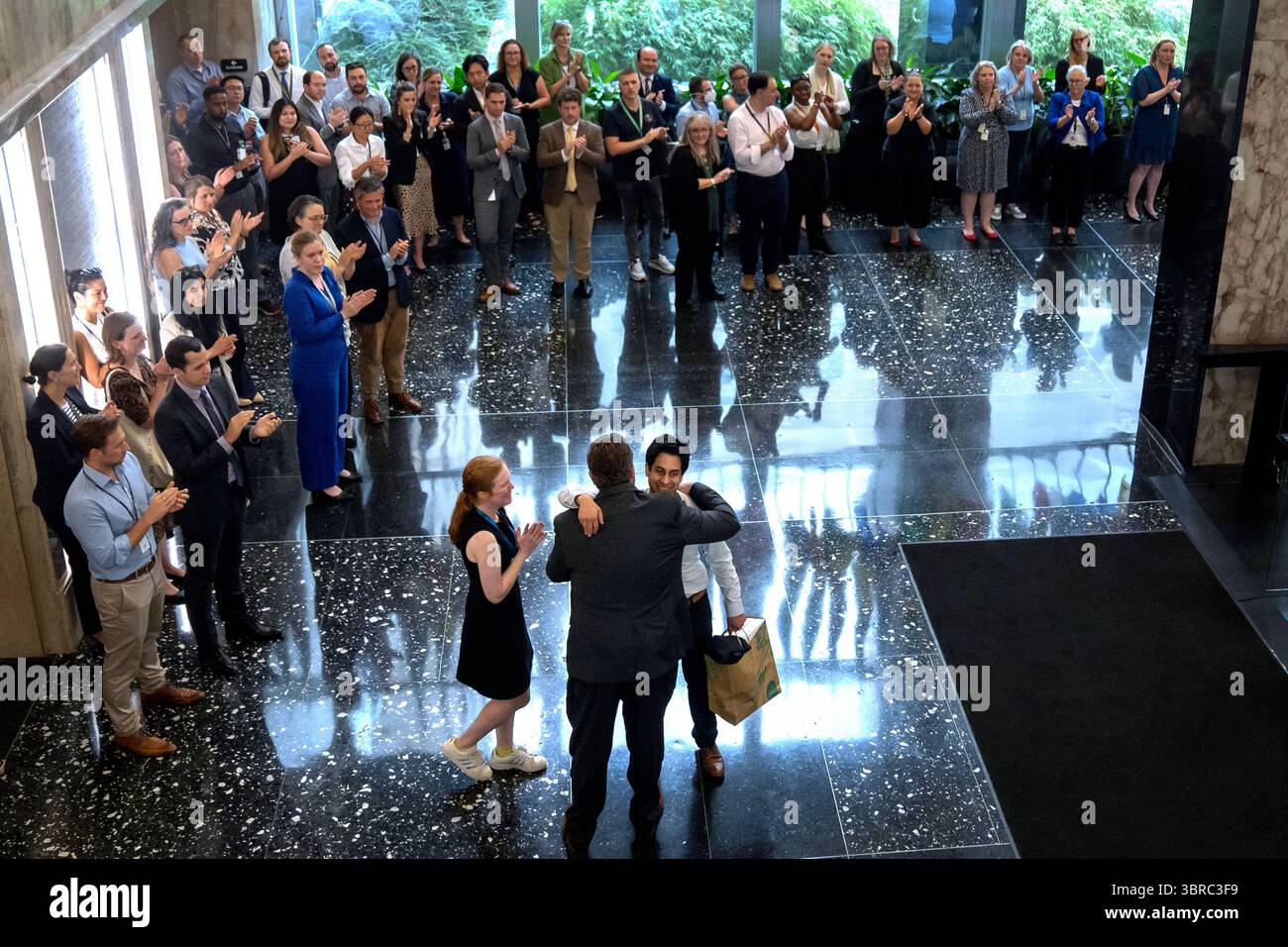 State Department employees applaud as their colleagues walk through the ...