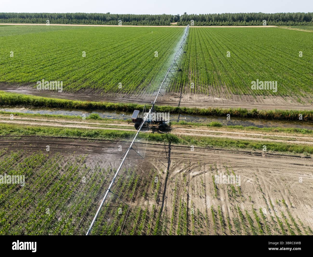Autonomous machine is moving watering pivot along irrigation canal ...