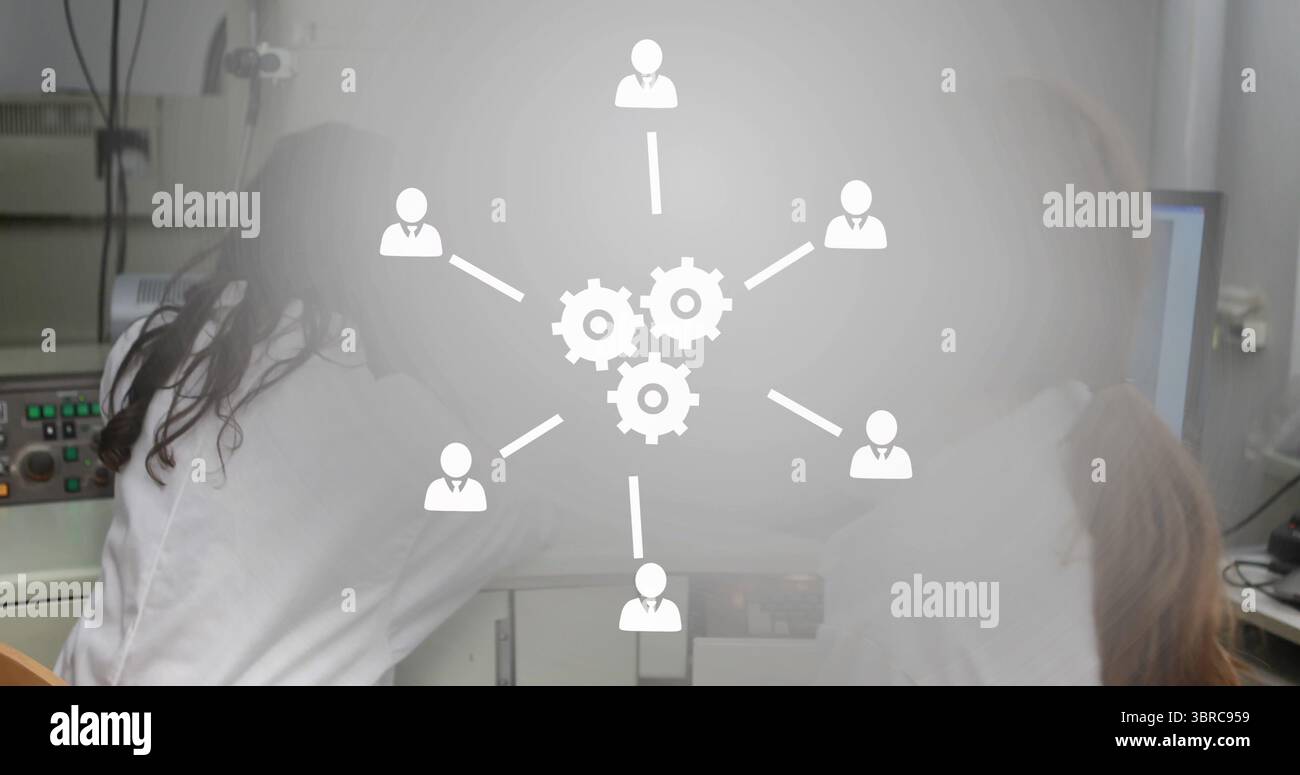 Lab technicians operating computer monitor and microscope in research ...