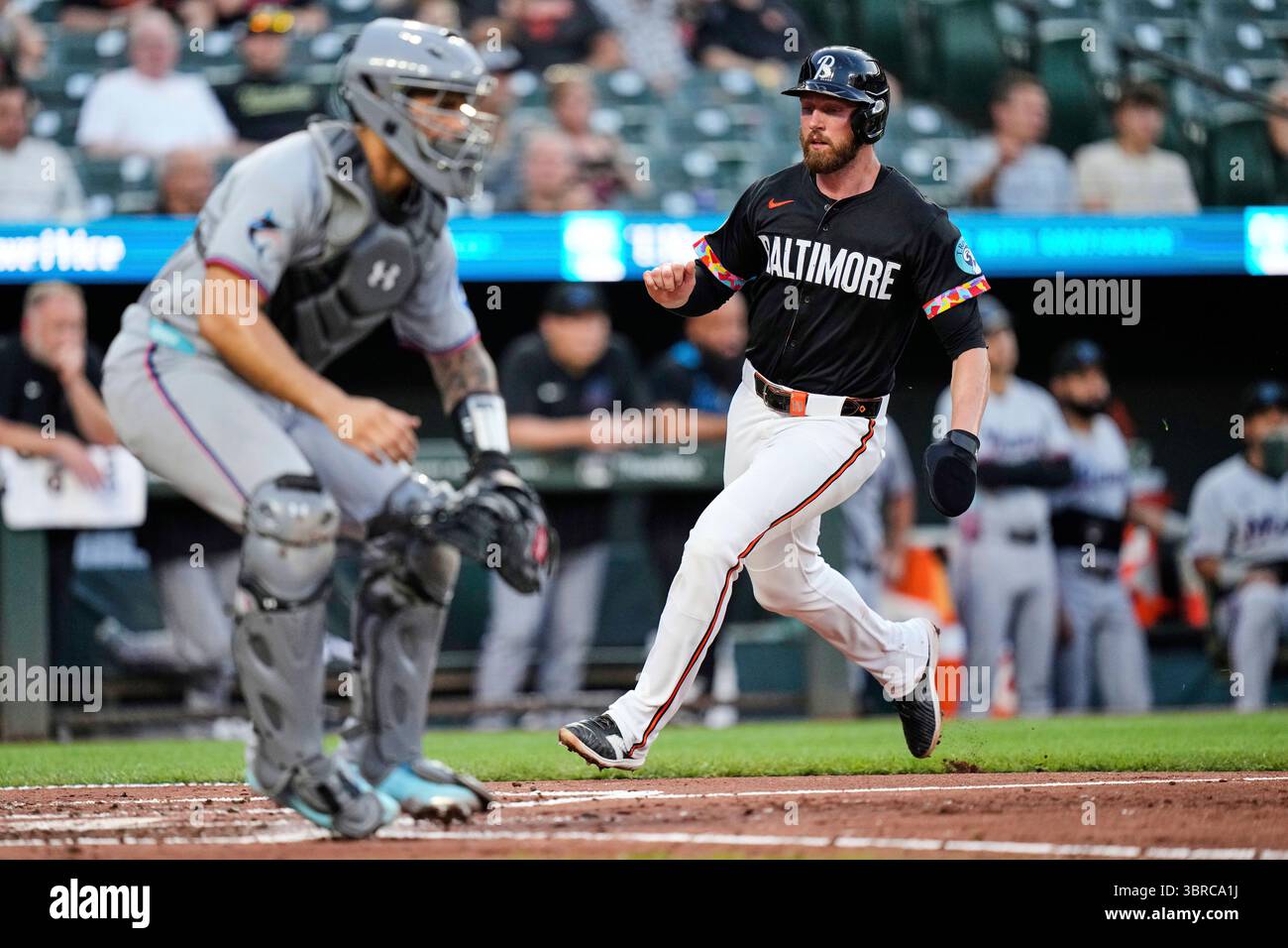Baltimore Orioles' Jordan Westburg, right, scores past Miami Marlins ...