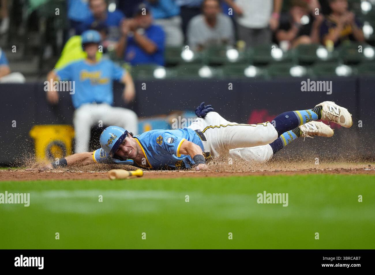 Milwaukee Brewers' Sal Frelick slides safely at home to score a run ...