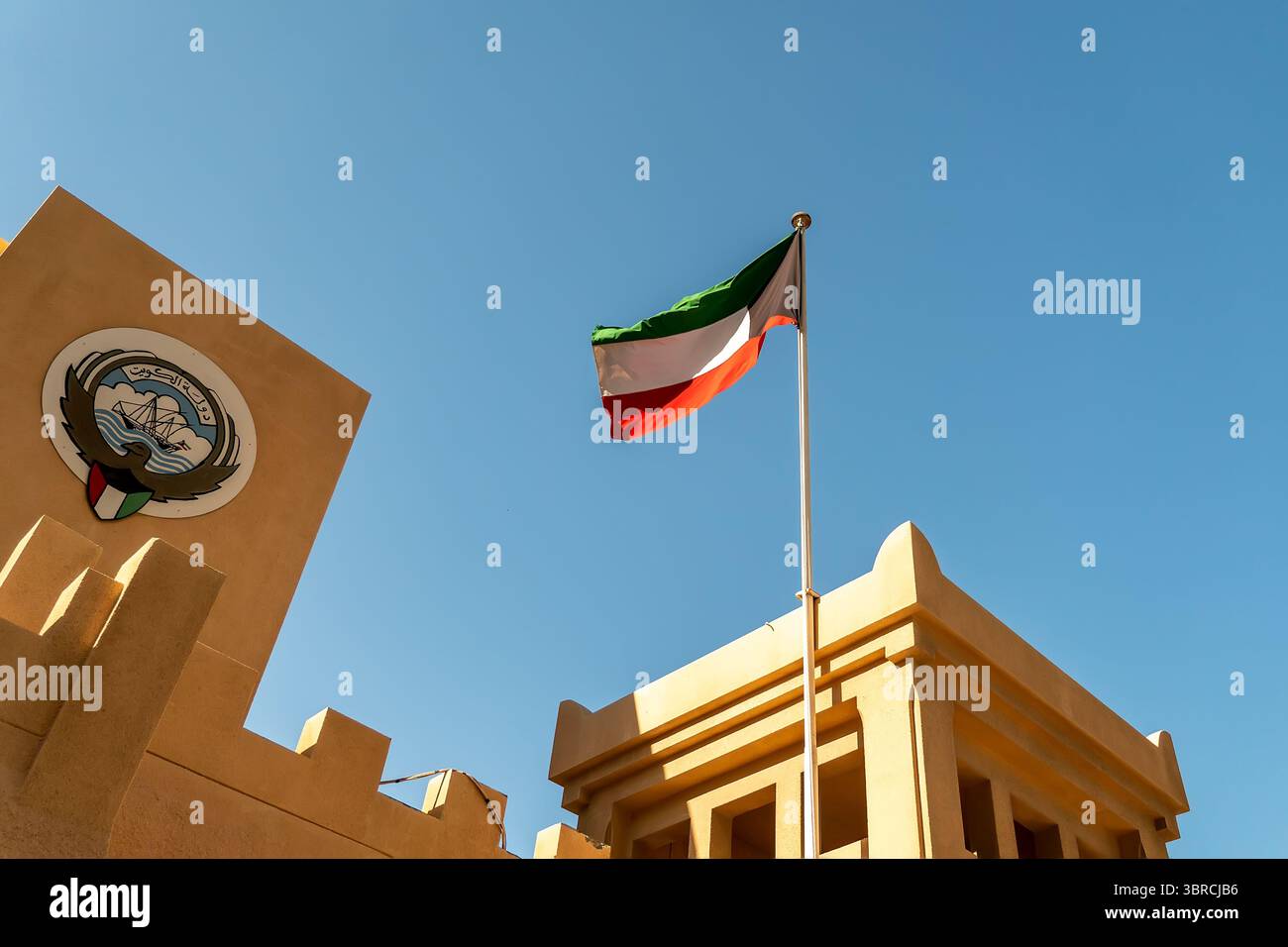 Kuwaiti national flag and state emblem on a traditional government ...
