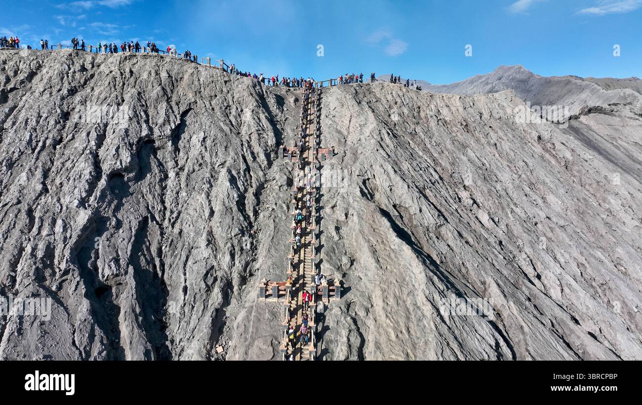 Adventurers climb a dramatic staircase carved into the rugged volcanic ...