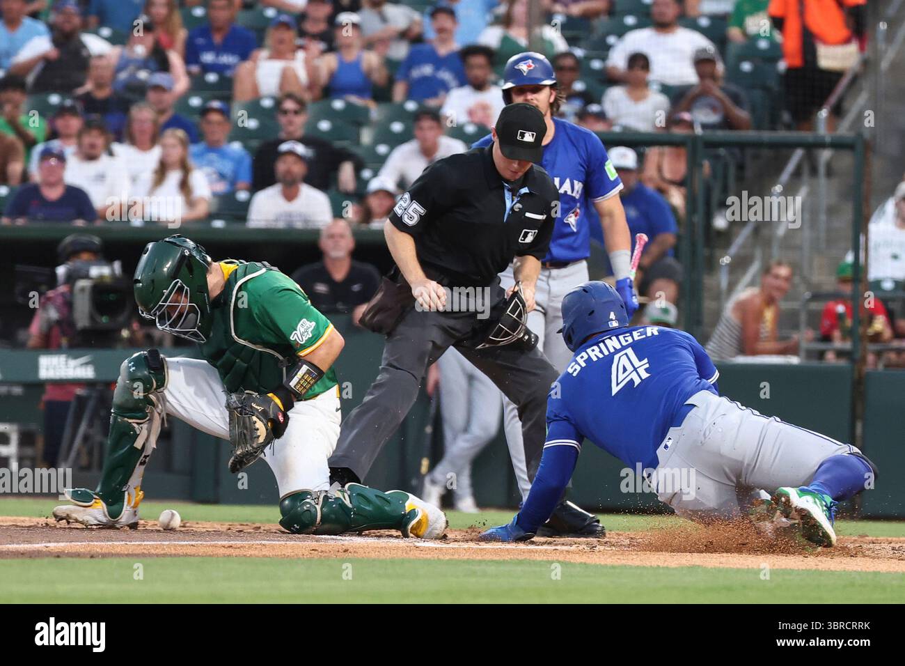 Athletics catcher Shea Langeliers, left, attempts to tag out Toronto ...