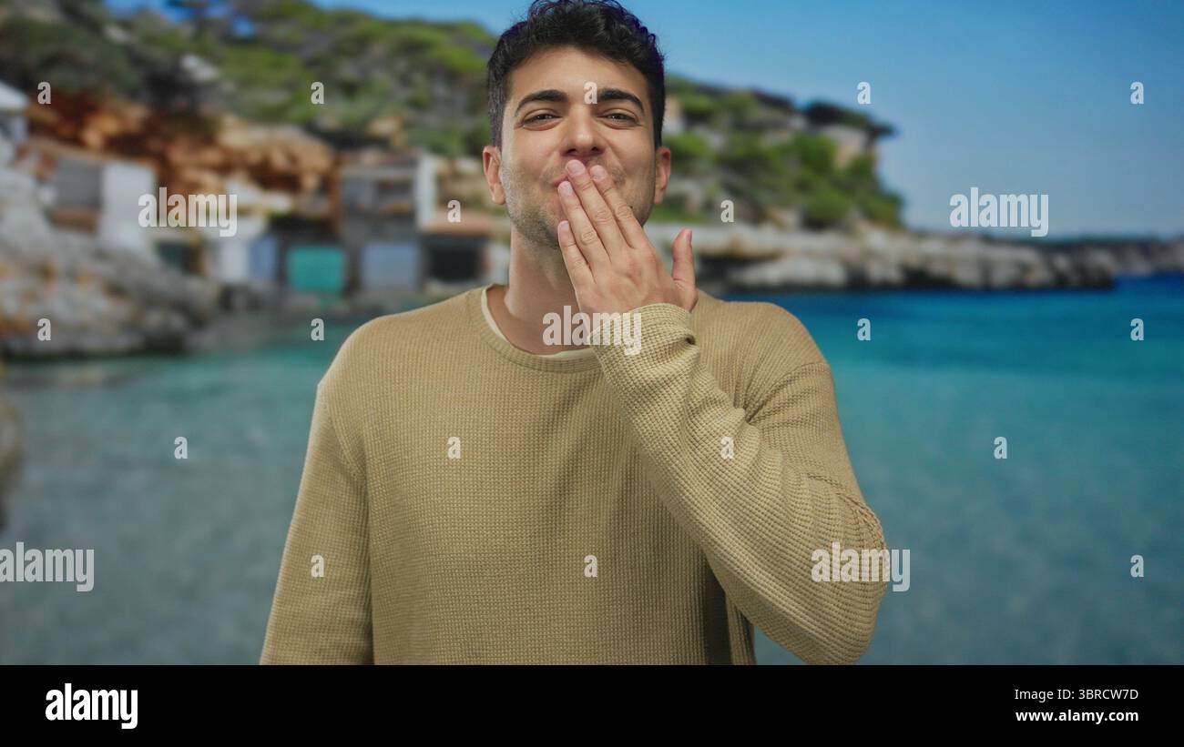 Man raises hand and blows gently toward camera in outdoor setting with ...