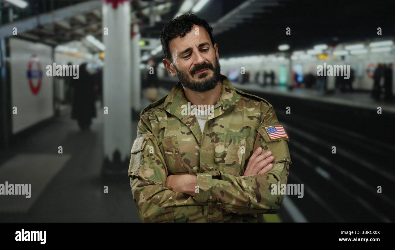 Man in military uniform standing in an underground station with arms ...