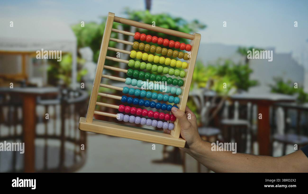 Man holding colorful abacus on city terrace restaurant creating a ...